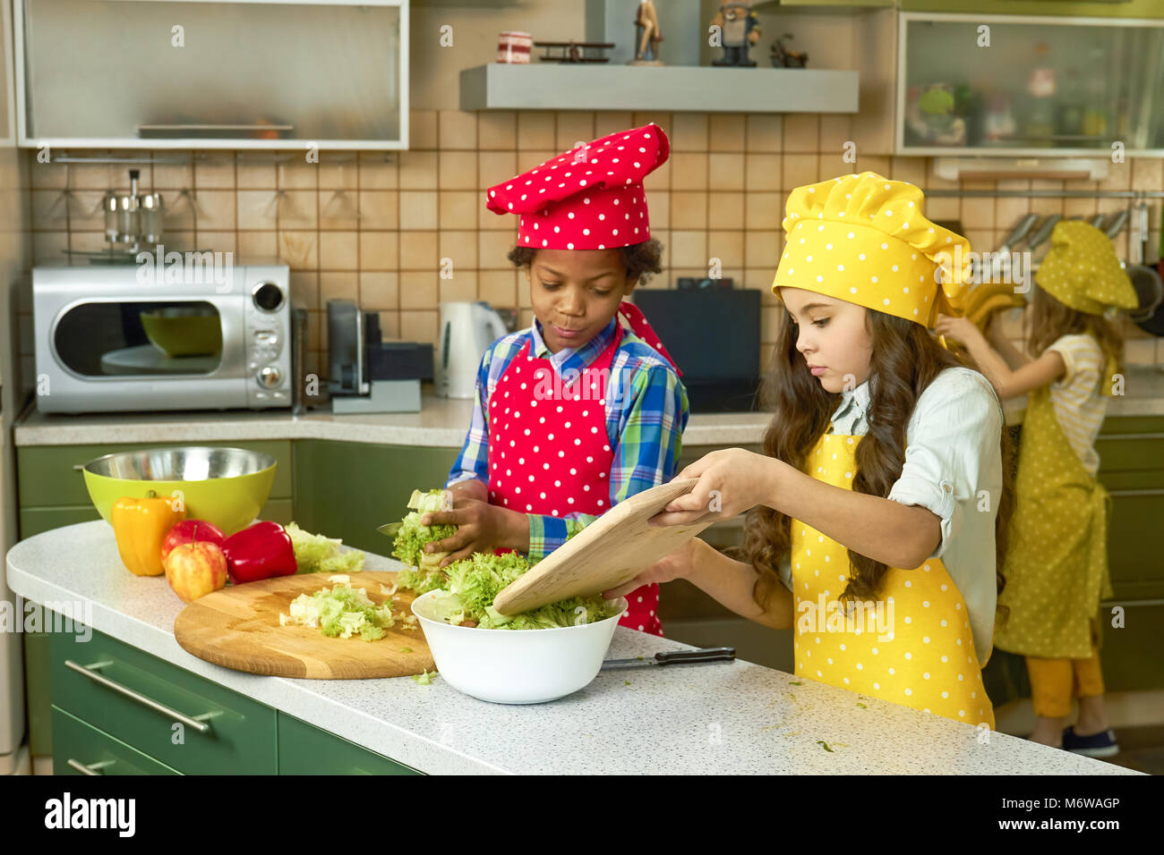 Kids cooking at kitchen table Stock Photo - Alamy