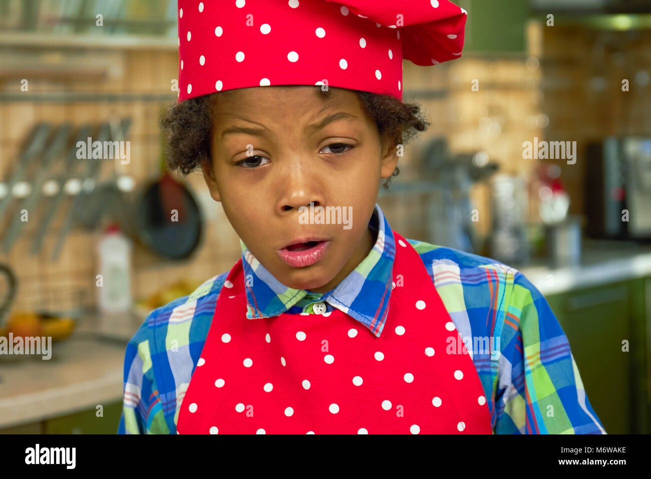 Upset kid in chef uniform Stock Photo - Alamy