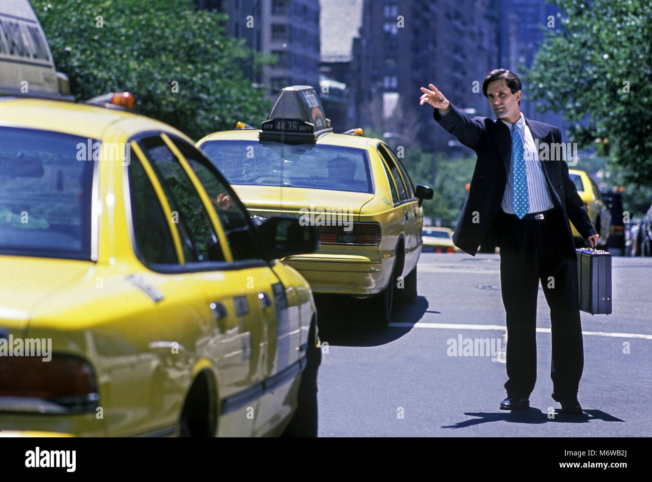 1994 HISTORICAL CAUCASIAN BUSINESS MAN HAILING YELLOW CHEVROLET IMPALA ...