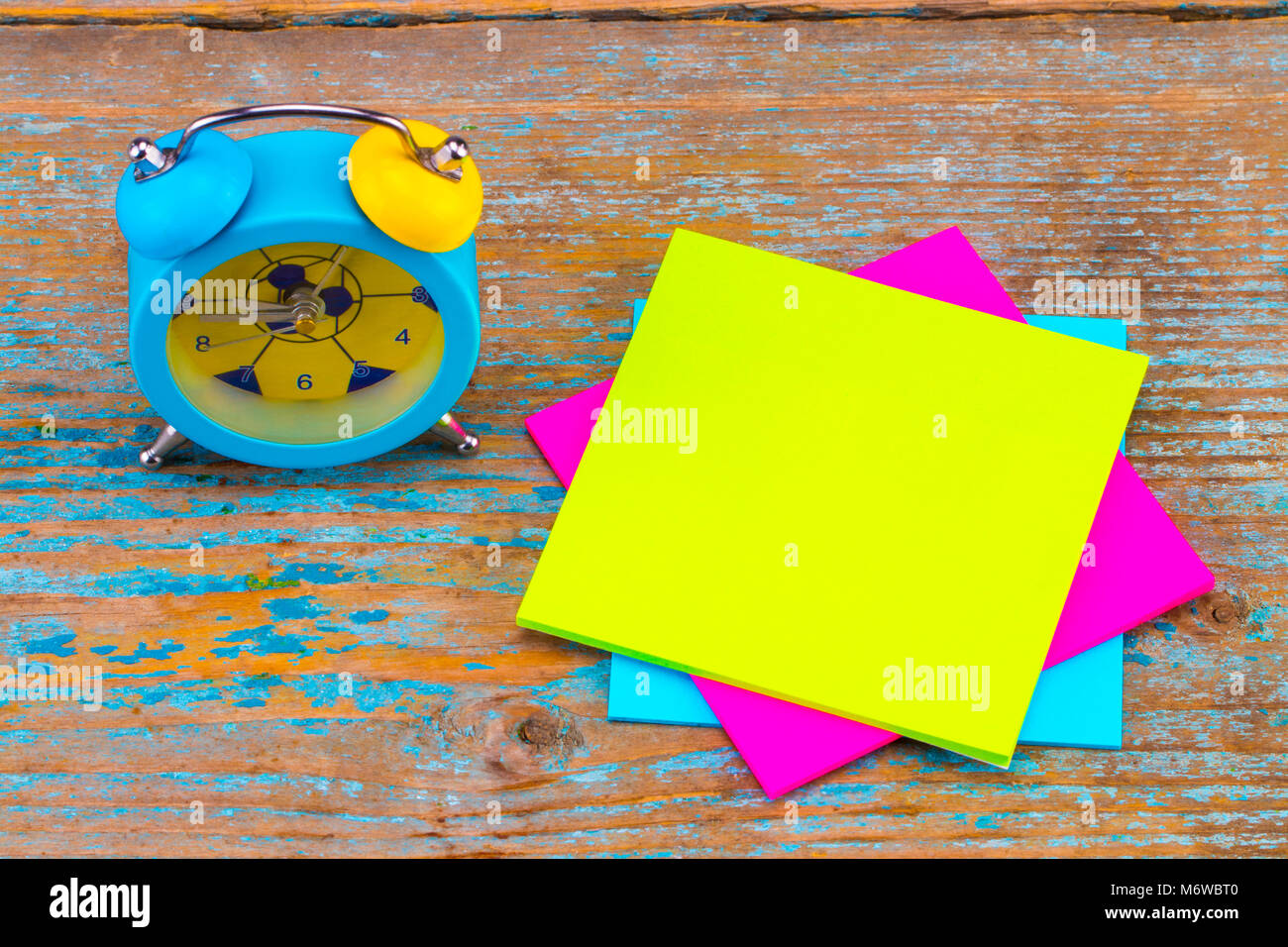 alarm clock and a sticky notes with empty space for a text on wooden ...