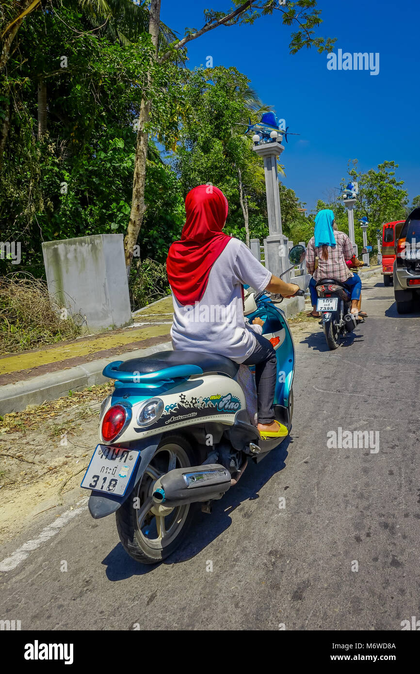AO NANG, THAILAND - MARCH 19, 2018: Unidentified people riding a motorcycle in the streets close ...