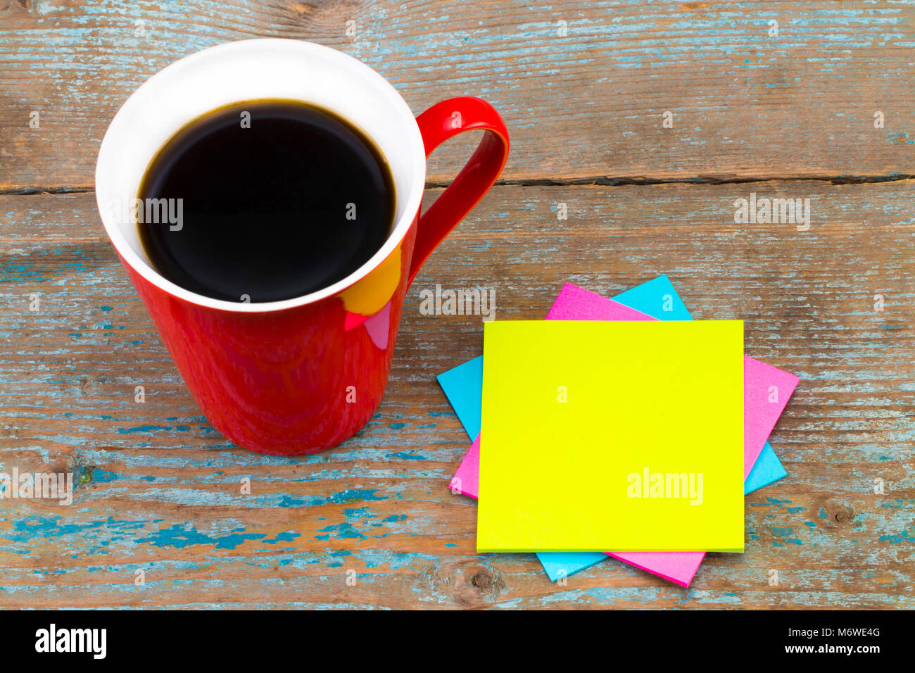 Cup of coffee and a sticky notes with empty space for a text on wooden ...