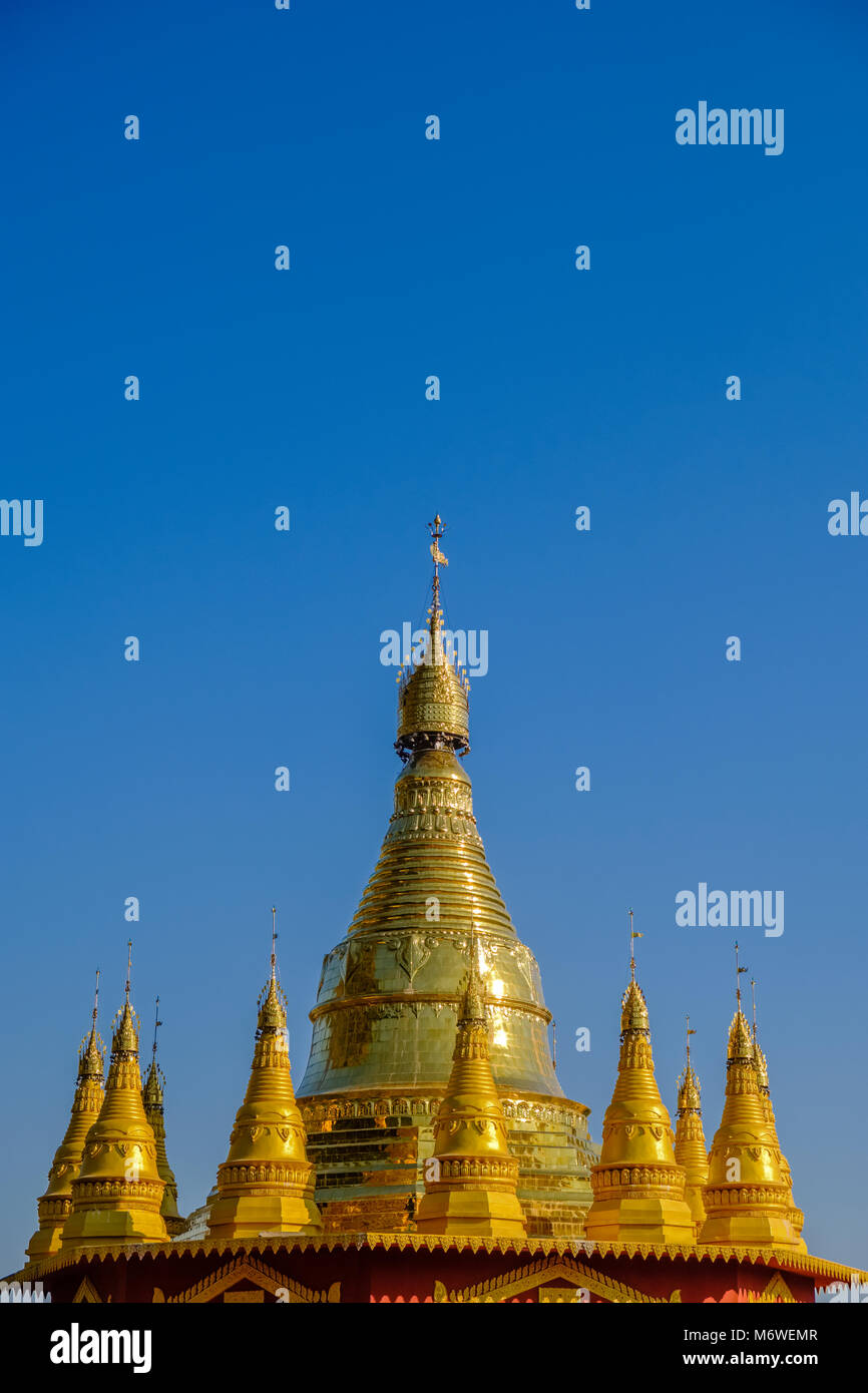 The golden tip of a pagoda at the entrance of Kaw-goon cave, also known ...