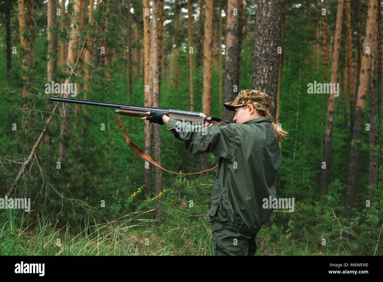 Woman hunter with a gun. Hunting in the woods Stock Photo - Alamy
