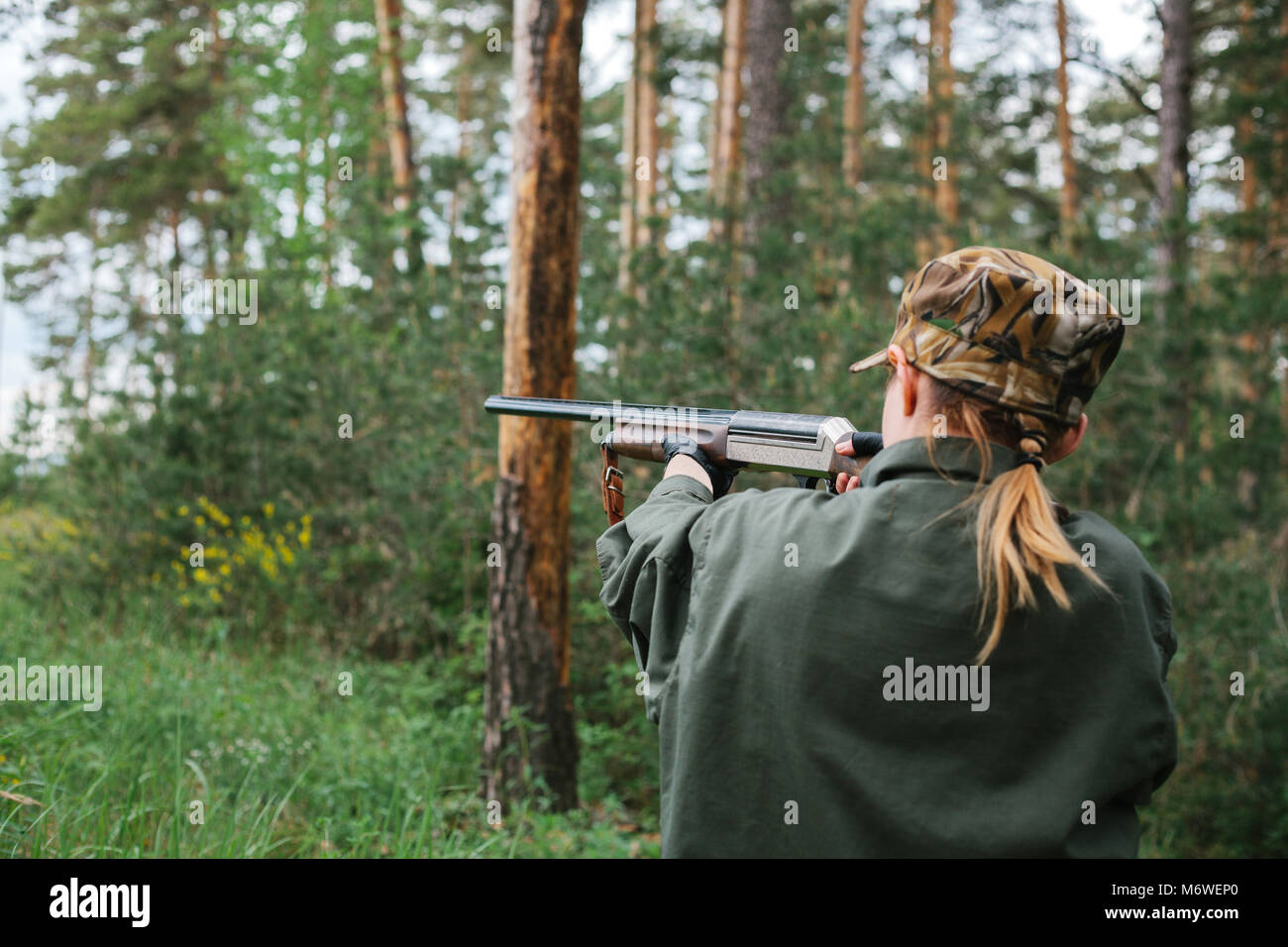 Woman hunter with a gun. Hunting in the woods Stock Photo - Alamy