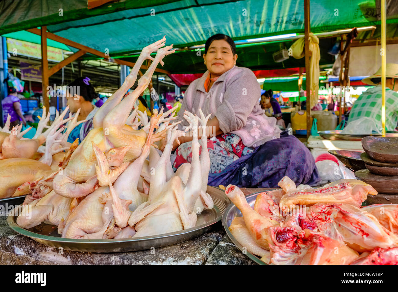 A local farmers woman is selling chicken meat in the street market of ...