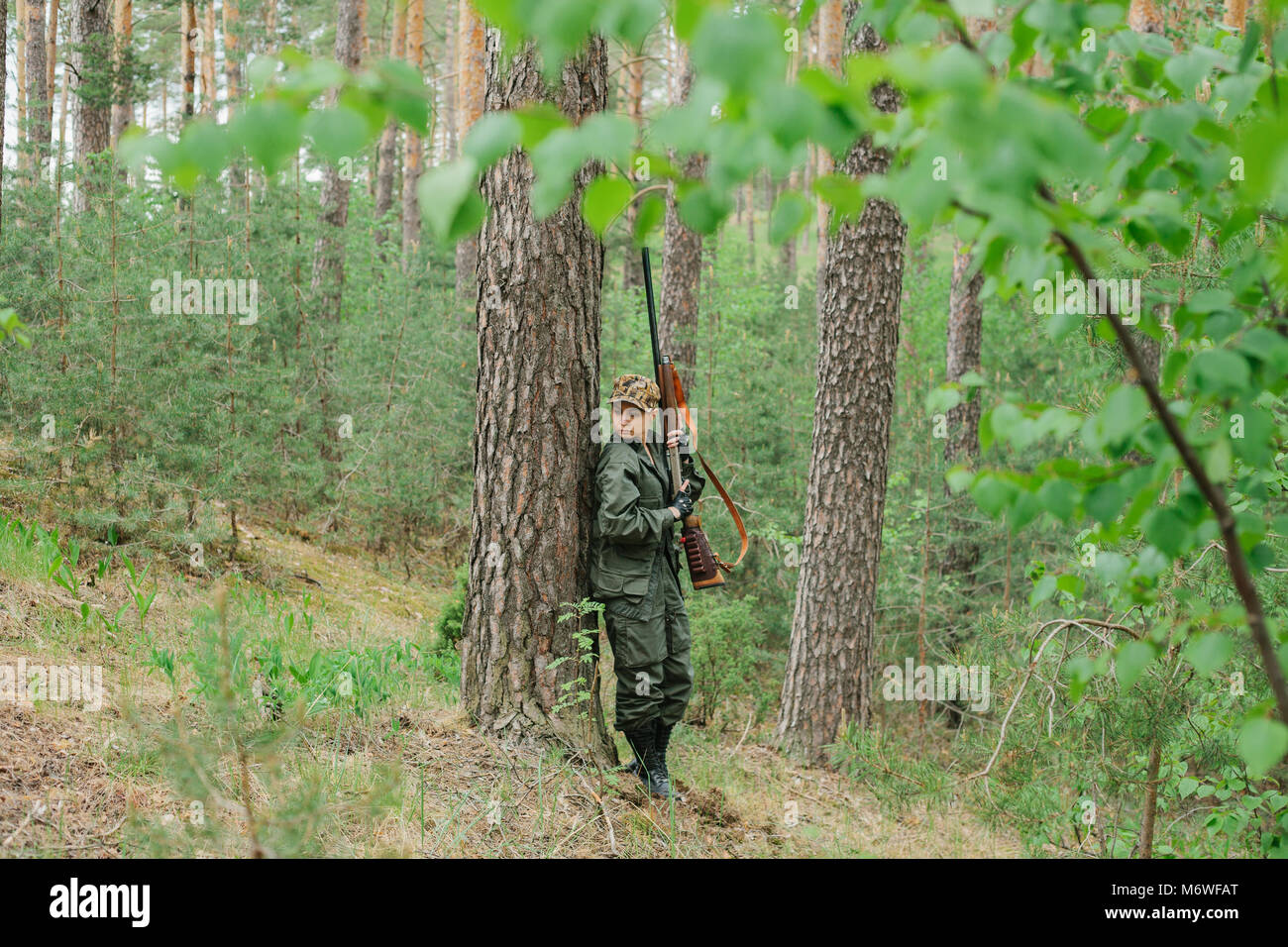 Woman hunter with a gun. Hunting in the woods Stock Photo - Alamy