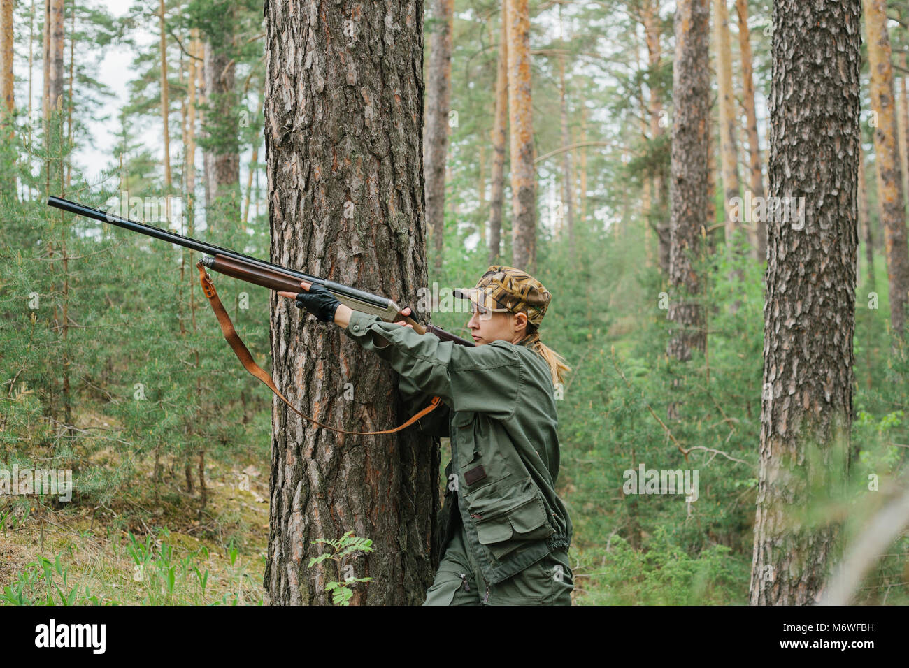Woman hunter with a gun. Hunting in the woods Stock Photo - Alamy
