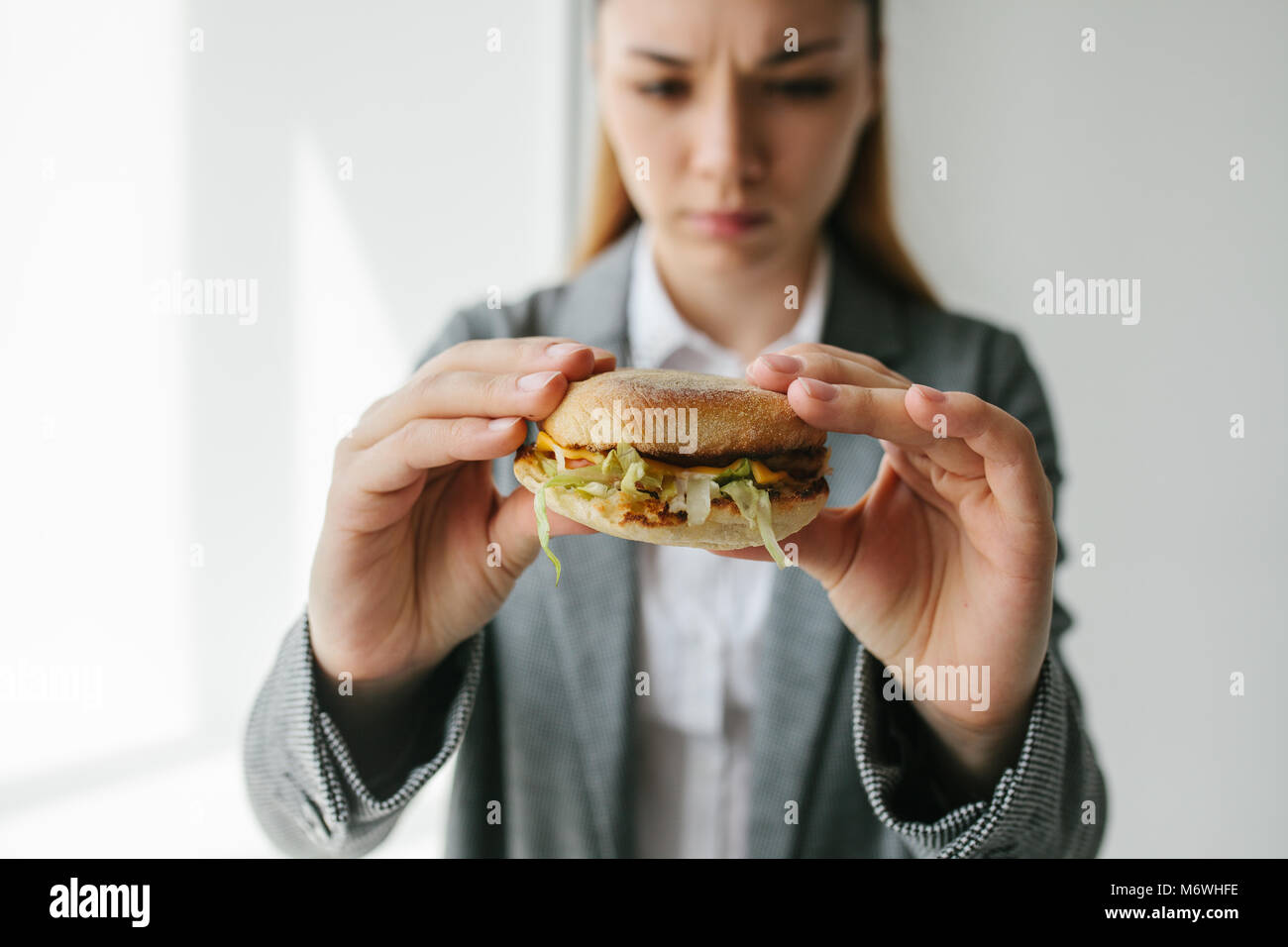 A young girl shows that she does not like a burger.Conceptual image of ...