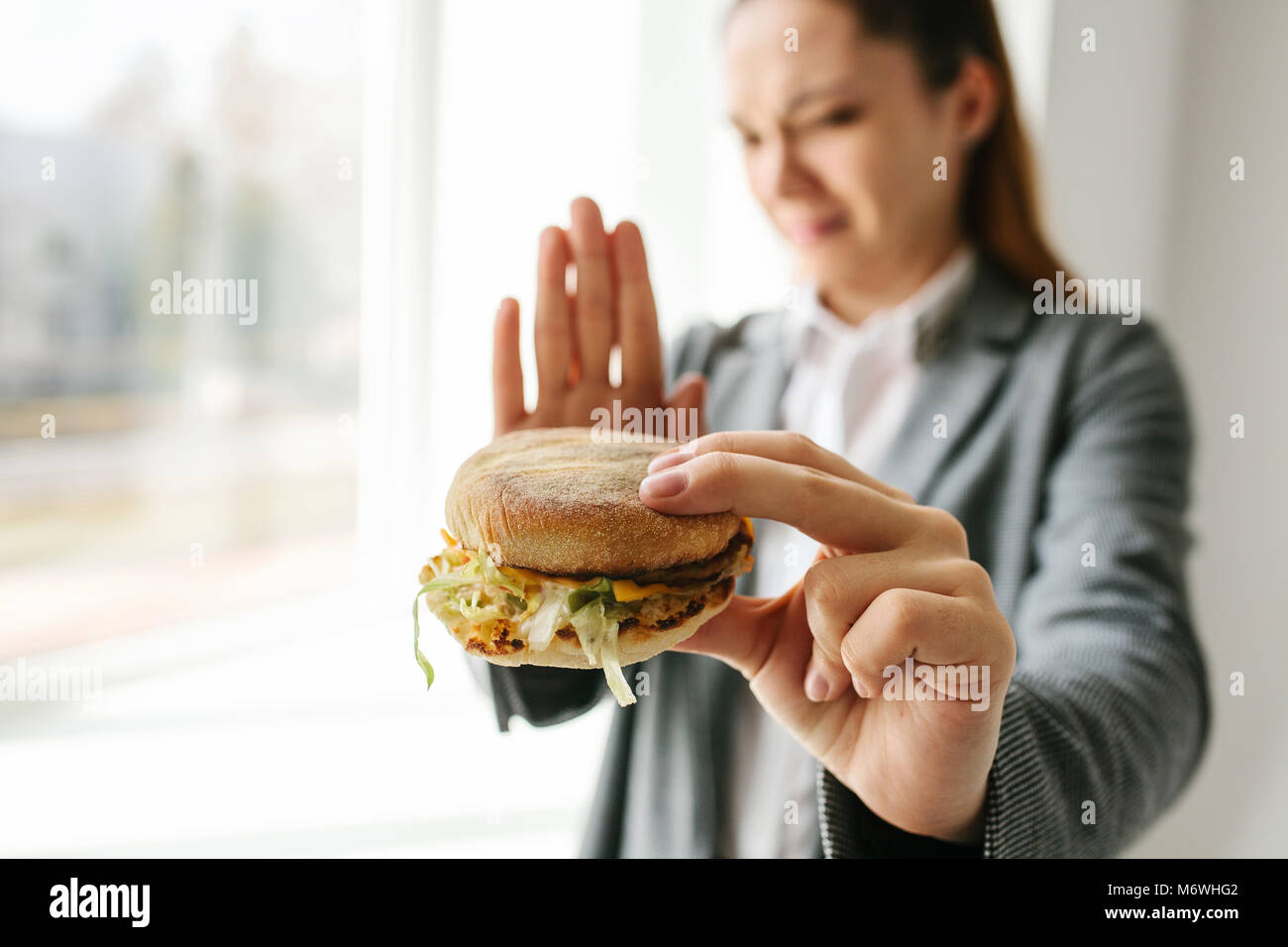 A young girl shows a sign by hand signifying there is no burger ...