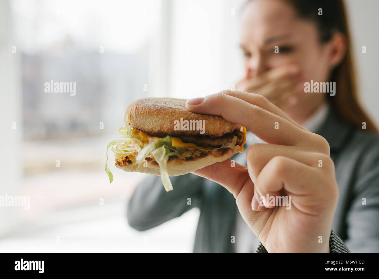 A young girl shows that she does not like a burger.Conceptual image of ...