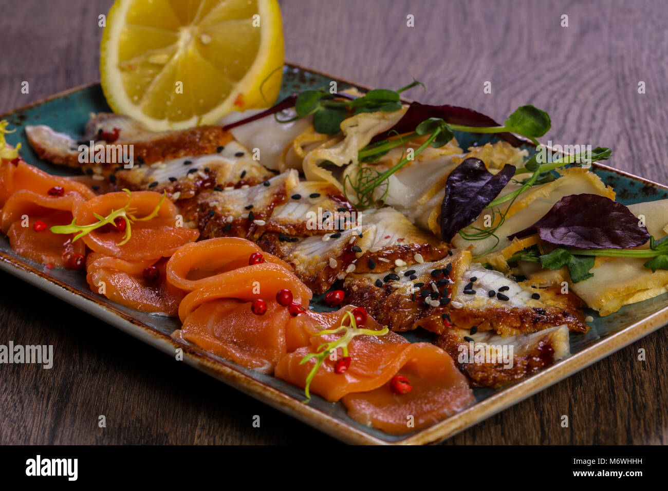 Sliced fish plate served lemon Stock Photo - Alamy