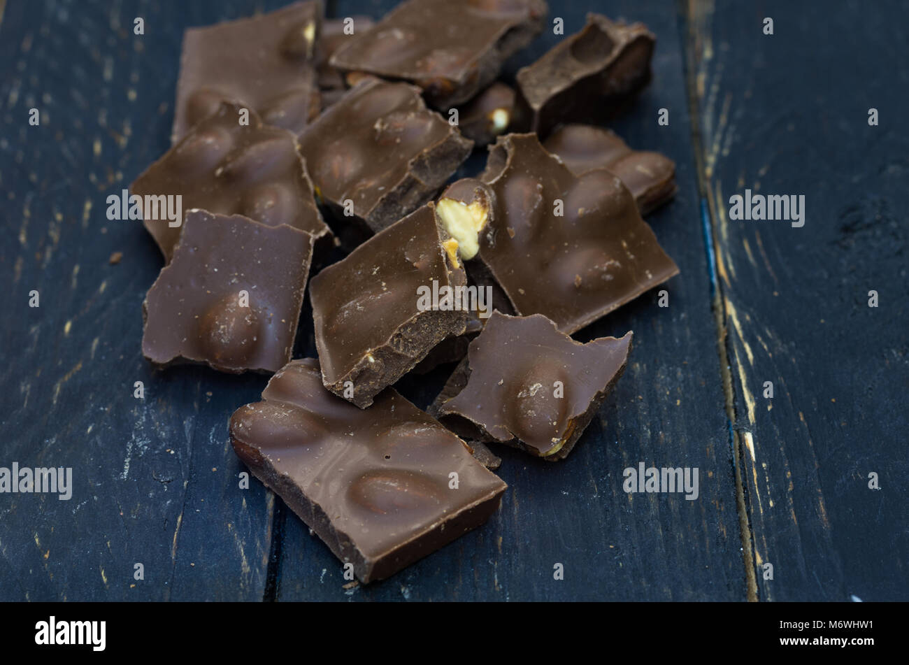Broken chocolate on the table. Wooden background. Front view Stock ...