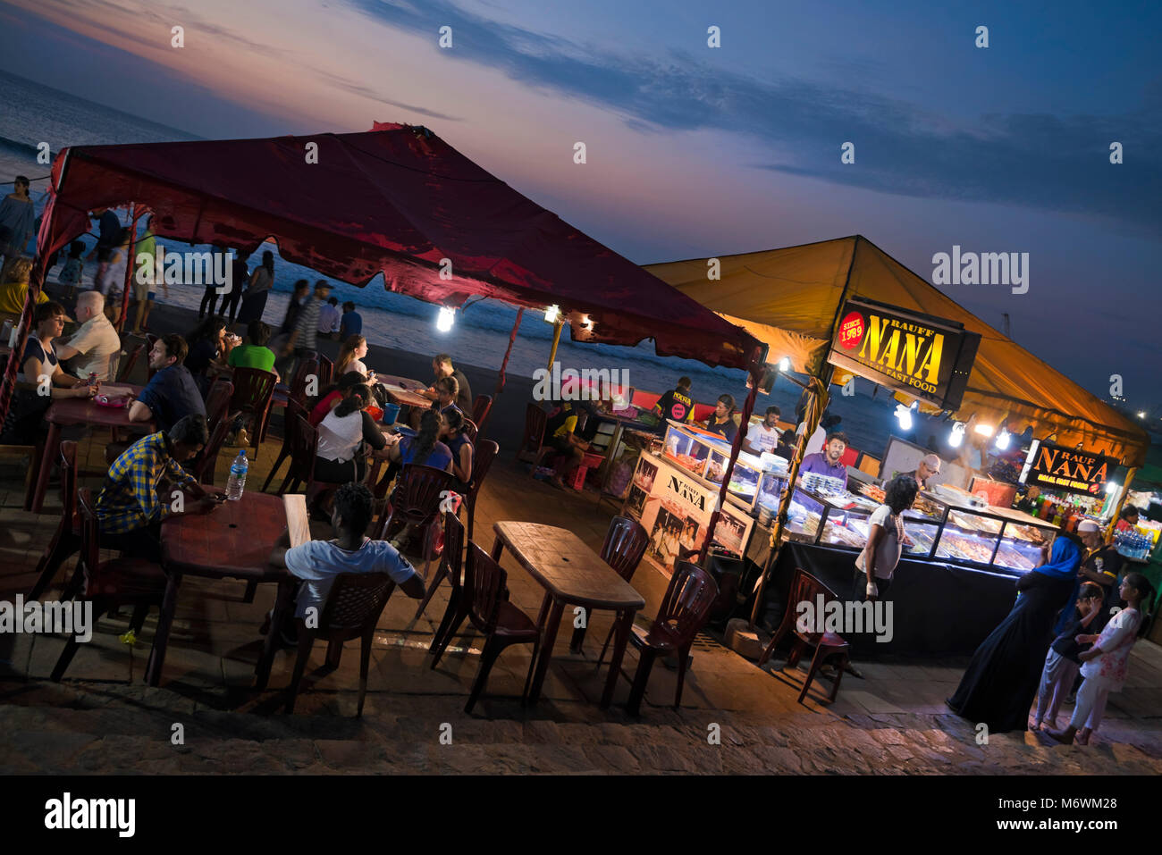 Horizontal view of people eating at a food stall on Galle Face Green in ...