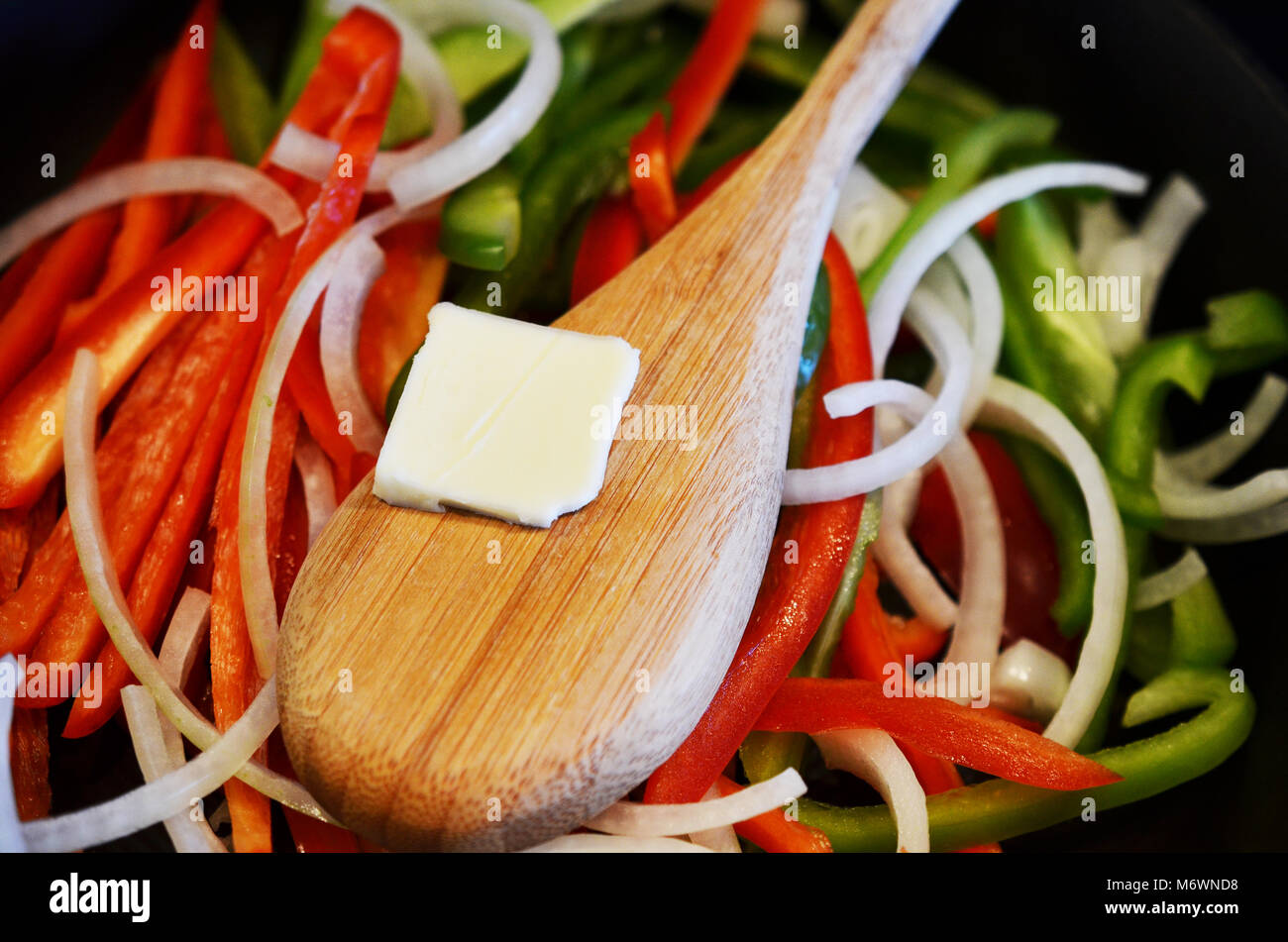 Wooden spoon with butter on top sauteing fresh vegetables Stock Photo ...
