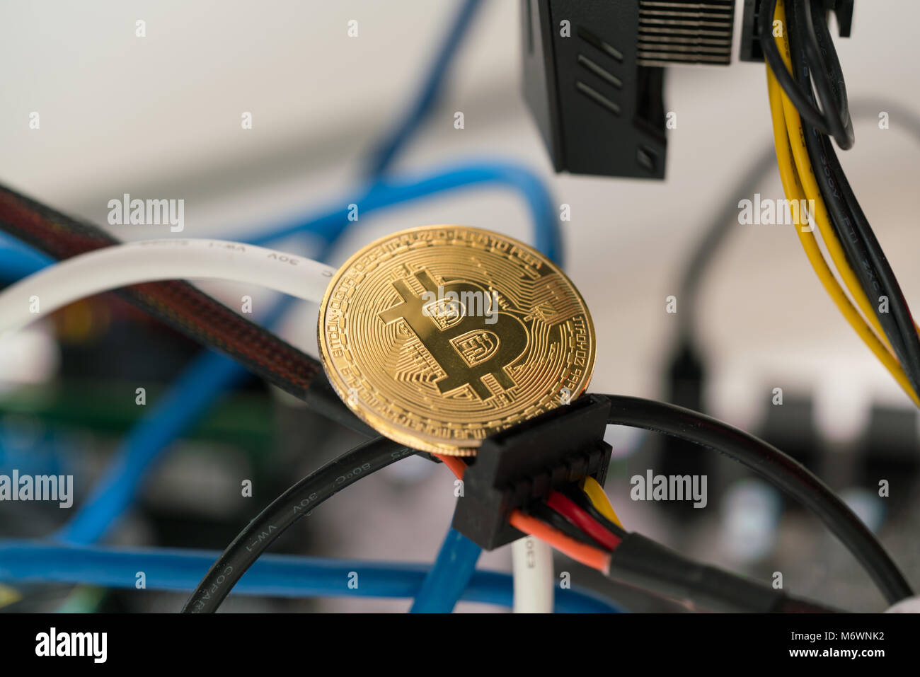 bitcoin against the background of cables in the rack for crypto ...