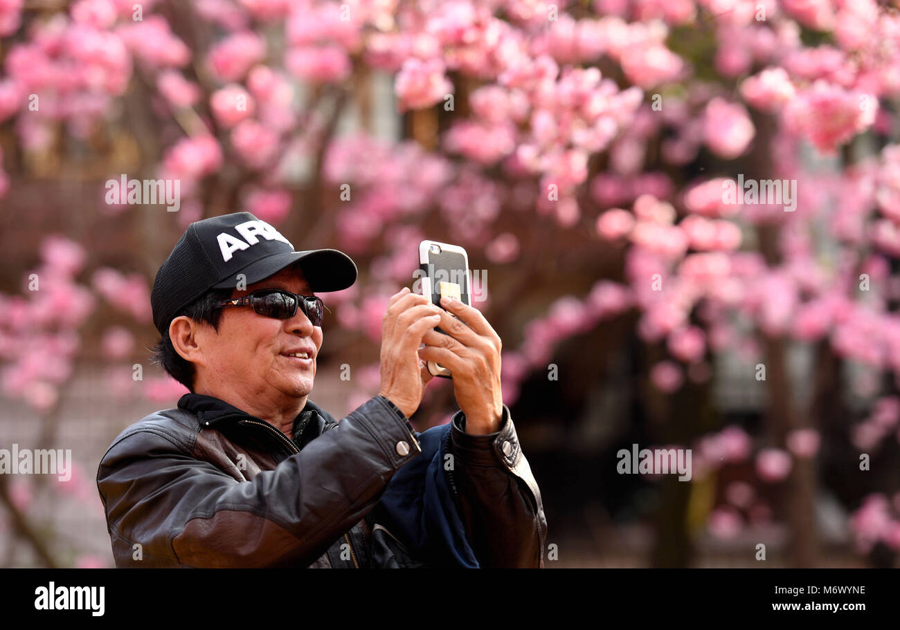 Kunming, China's Yunnan Province. 6th Mar, 2018. A man takes photos of ...