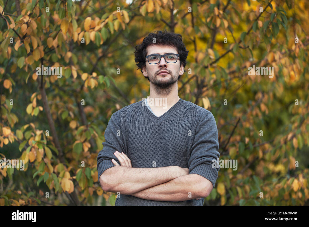 Assured man standing with cross hands Stock Photo - Alamy