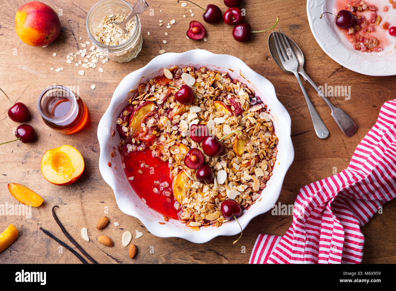 Peach and berry crumble in a baking dish. Top view Stock Photo - Alamy