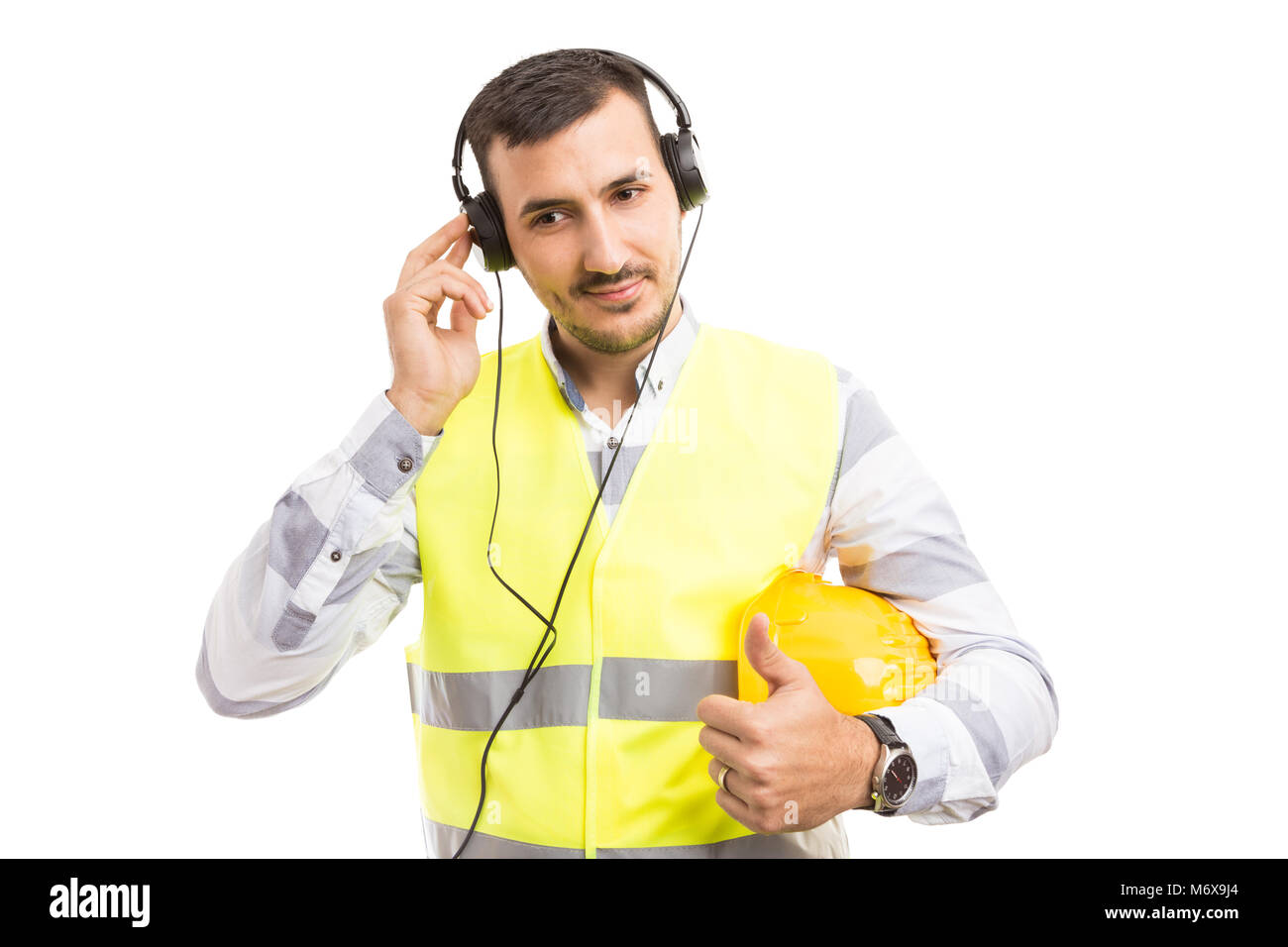 Handsome construction worker listening music on headphones and holding ...