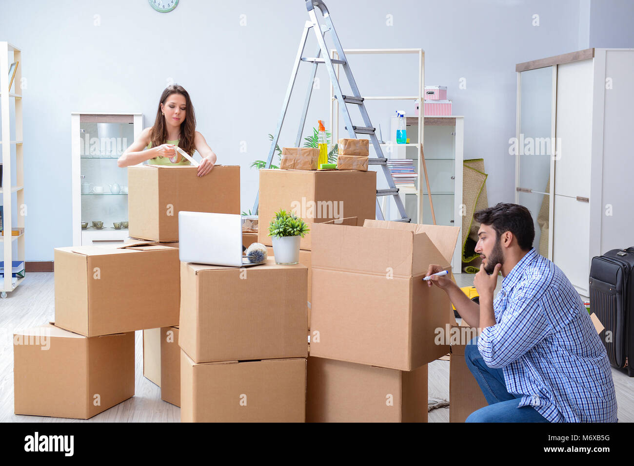 Young family unpacking at new house with boxes Stock Photo - Alamy