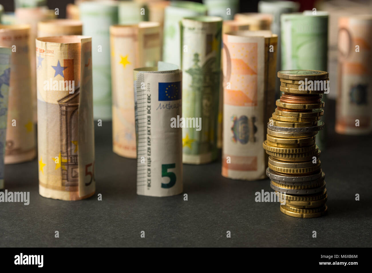 Stack of euro coins and rolls of bank notes in the background Stock ...