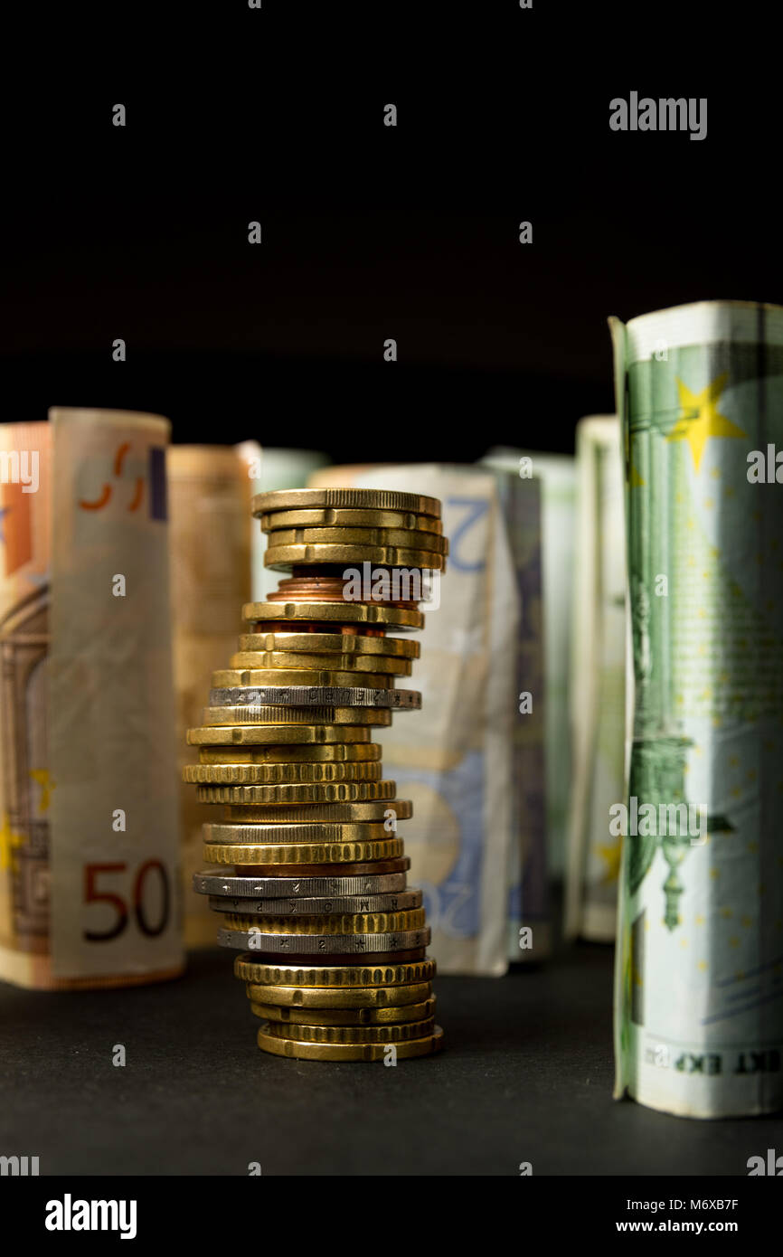 Stack of euro coins and rolls of bank notes in the background Stock ...