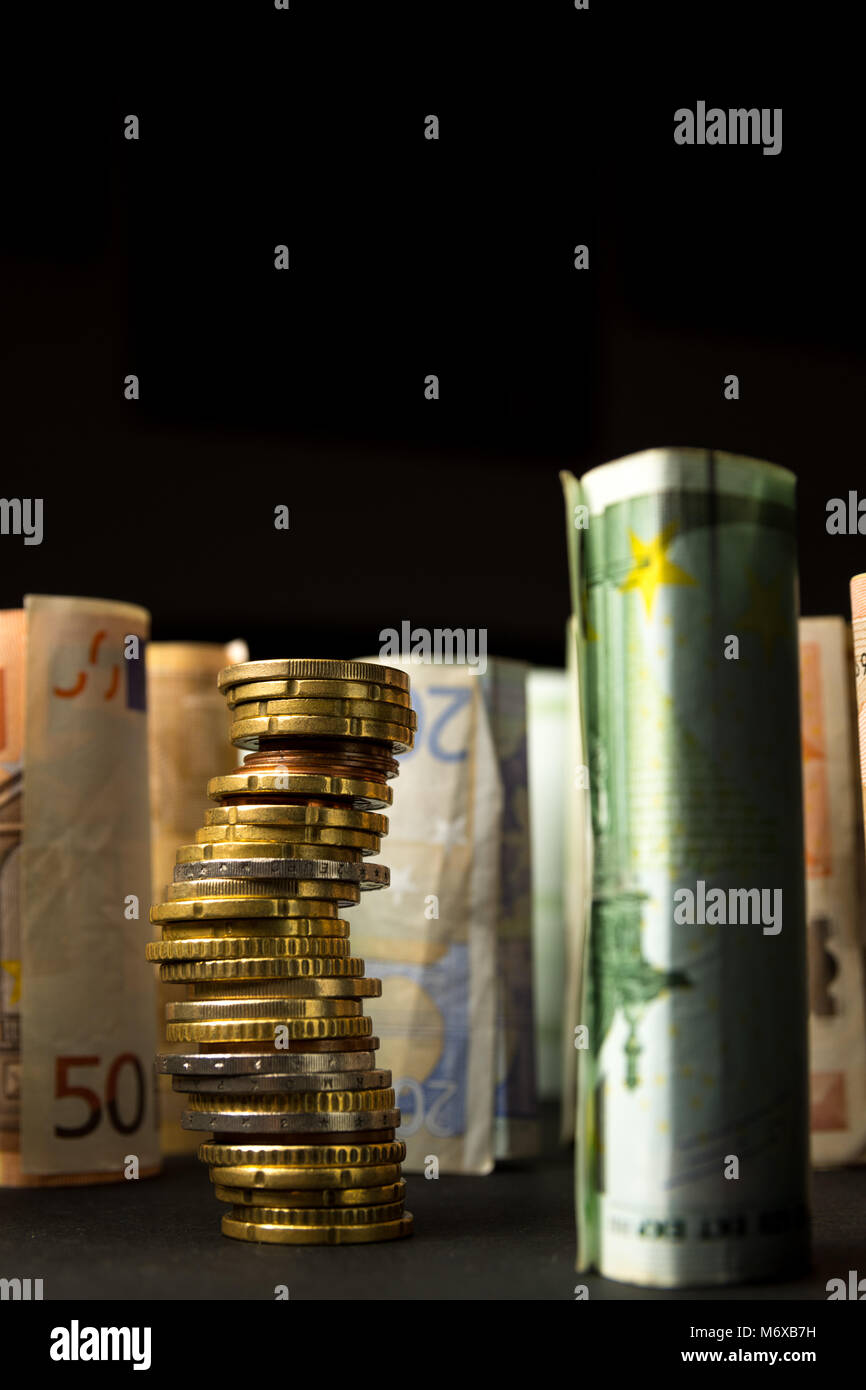 Stack of euro coins and rolls of bank notes in the background Stock ...