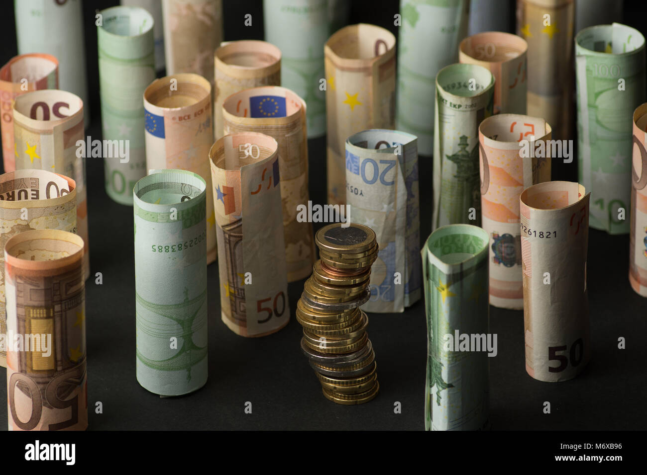 Stack of euro coins and rolls of bank notes in the background Stock ...