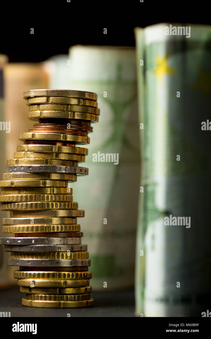 Stack of euro coins and rolls of bank notes in the background Stock ...