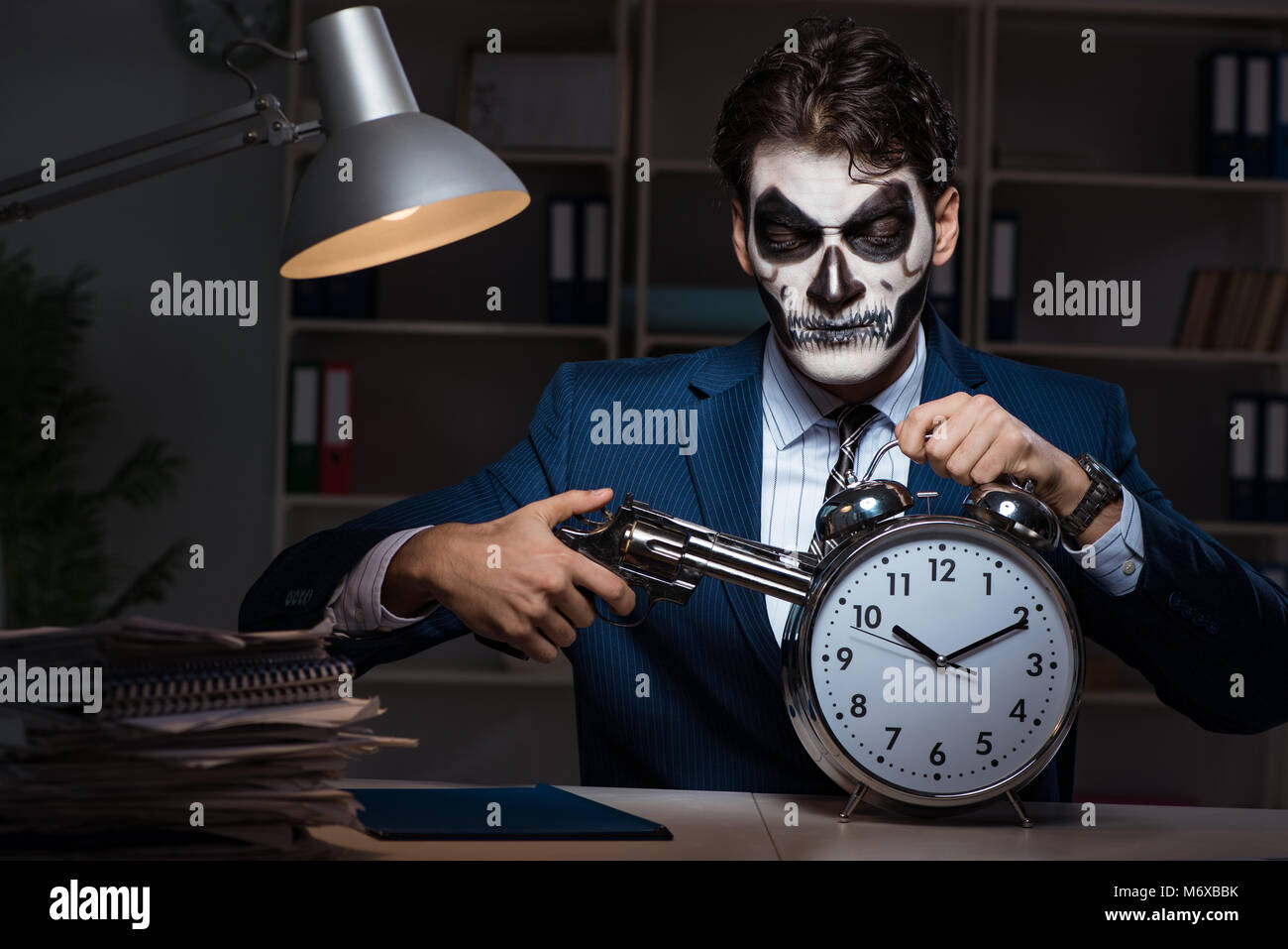 Businessman with scary face mask working late in office Stock Photo - Alamy