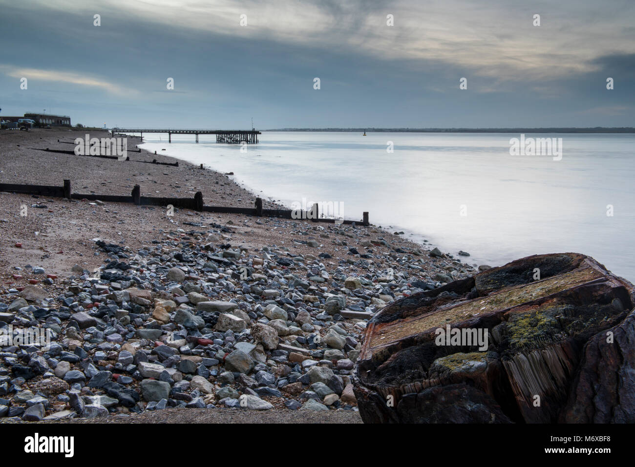 A beautiful and atmospheric seascape on a beach with rocks and an old ...
