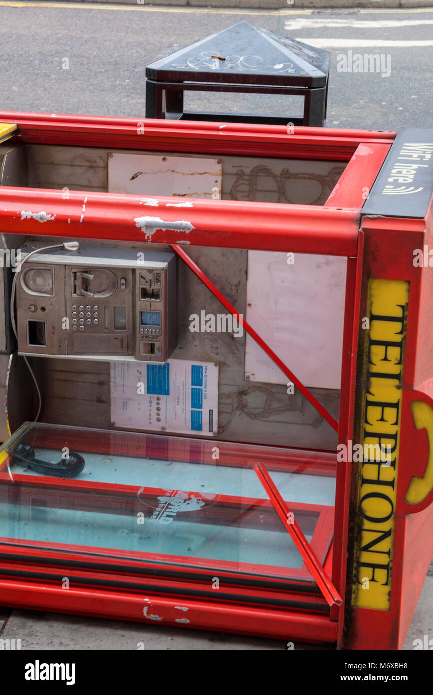 An old style red telephone coin operated card phone call box on it’s ...