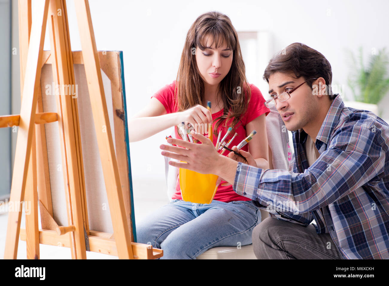 Artist coaching student in painting class in studio Stock Photo - Alamy
