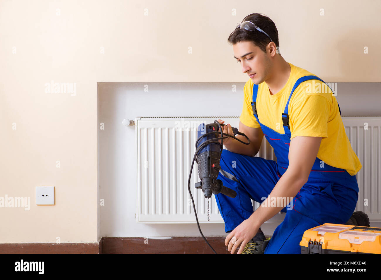 Young repairman contractor repairing heating panel Stock Photo - Alamy