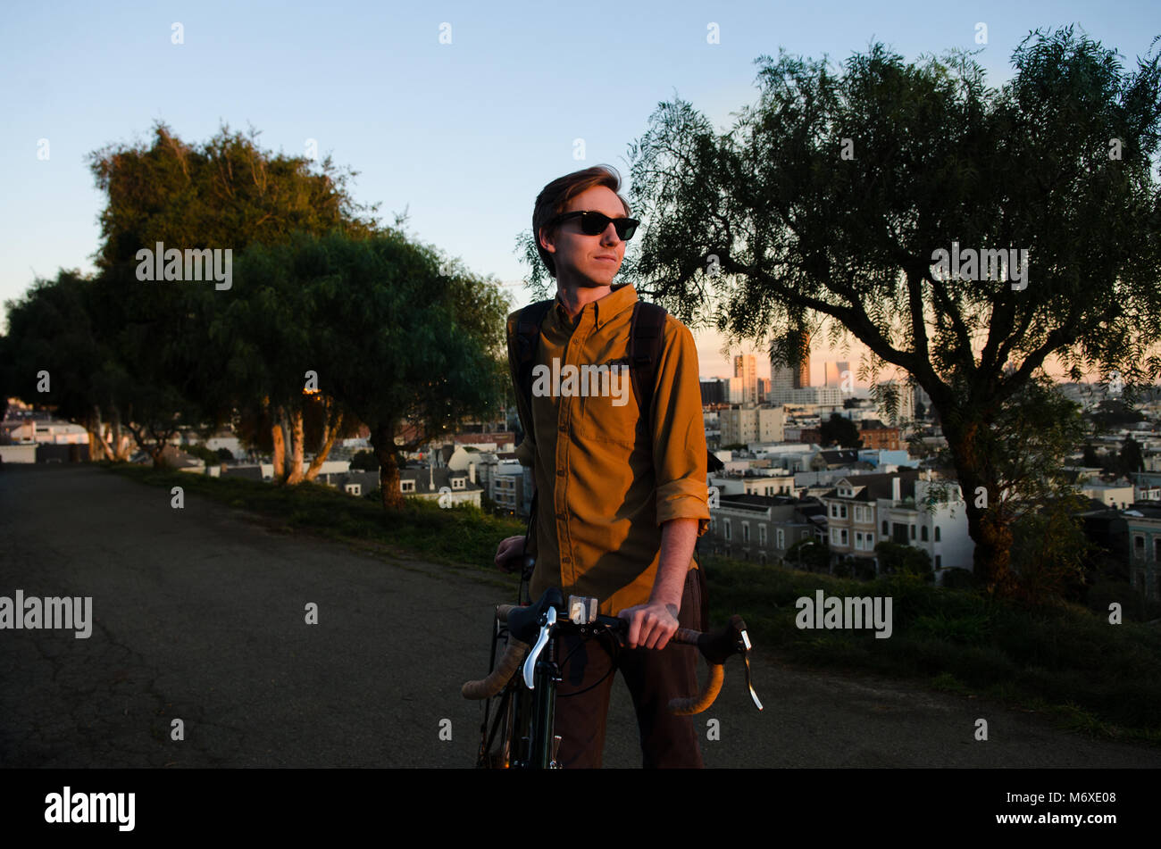 man walking his bike in a park Stock Photo - Alamy