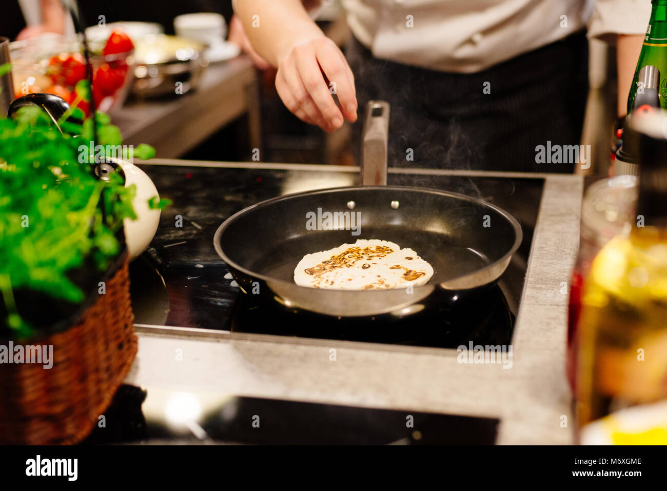 Woman frying tortilla wraps on frying pan in the kitchen Stock Photo ...