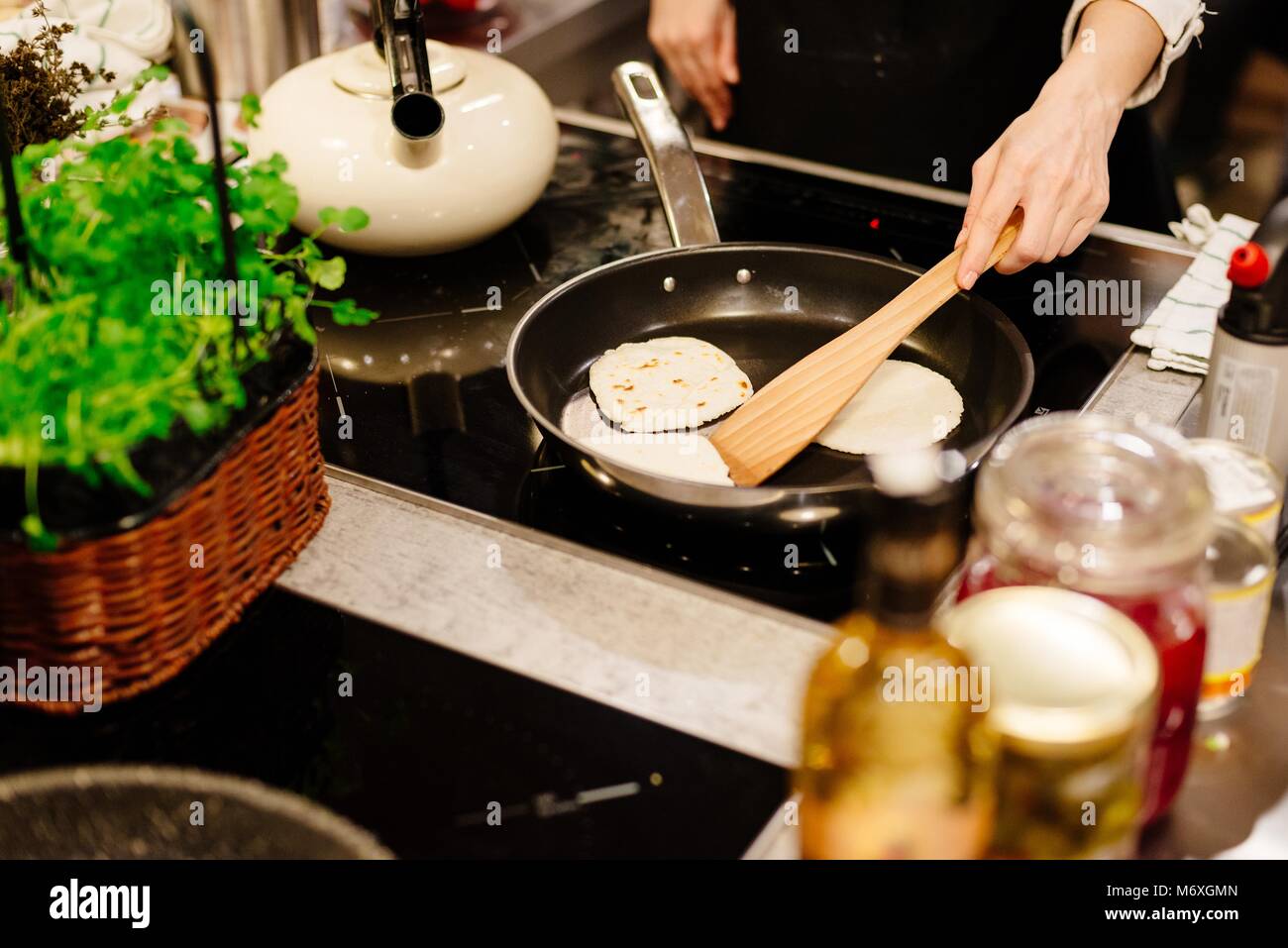 Woman frying tortilla wraps on frying pan in the kitchen Stock Photo ...