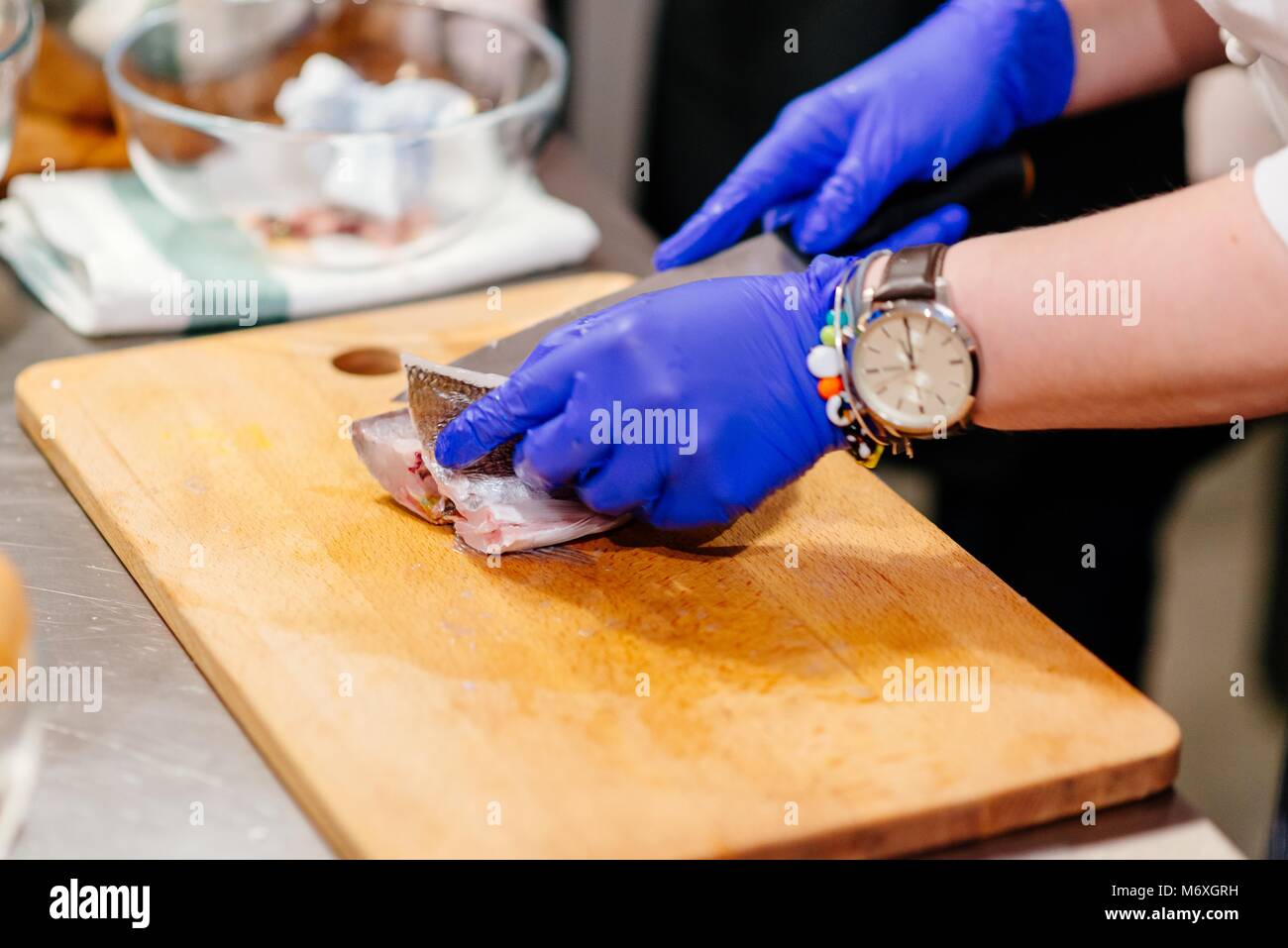Woman cook preparing and cleaning raw dorada fish with knife on the ...