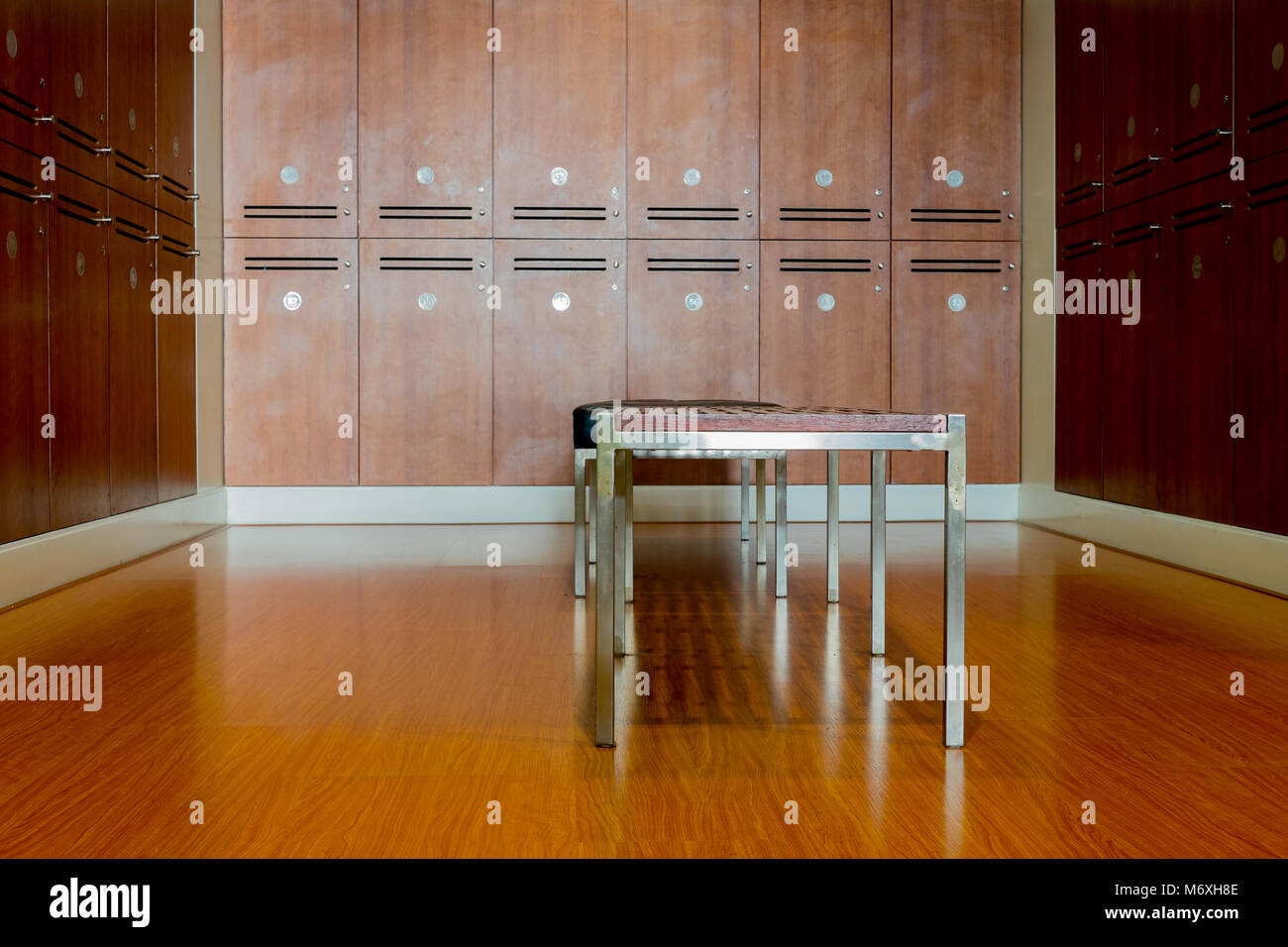 Locker room, cabinet and bench - focus on the bench Stock Photo - Alamy