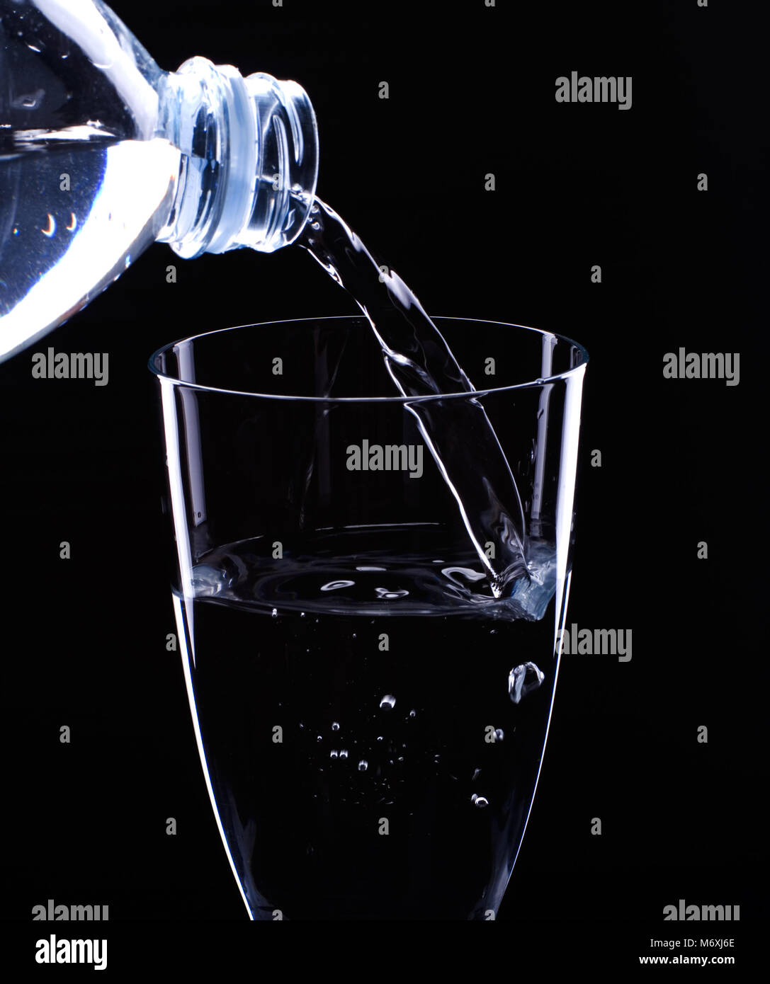 Water flows from a bottle in a glass Stock Photo - Alamy