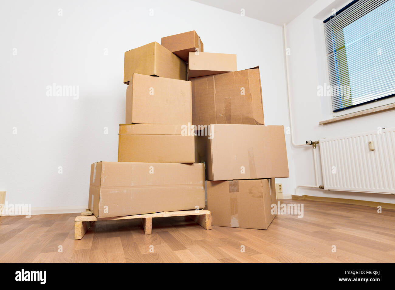 Moving in new apartment. Empty room with boxes Stock Photo - Alamy