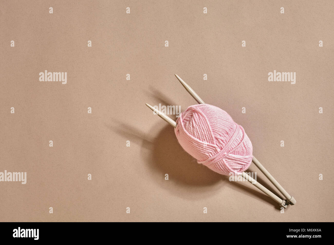 Pink knitting yarn ball and knitting needles top view Stock Photo - Alamy
