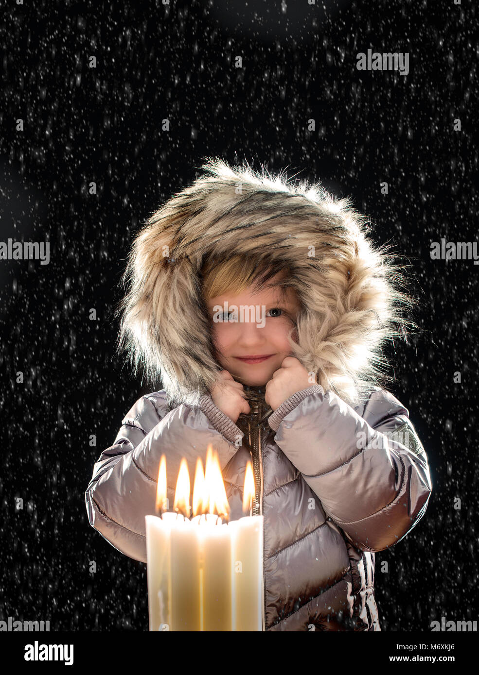 Girl with candles with snow falling Stock Photo - Alamy