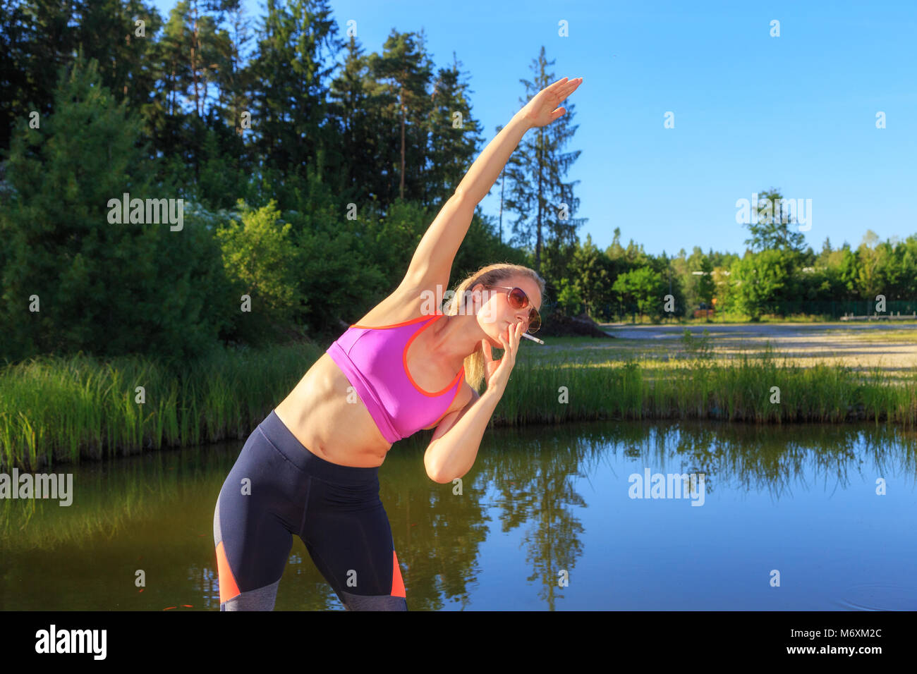 A sporty woman smokes while doing sports Stock Photo - Alamy