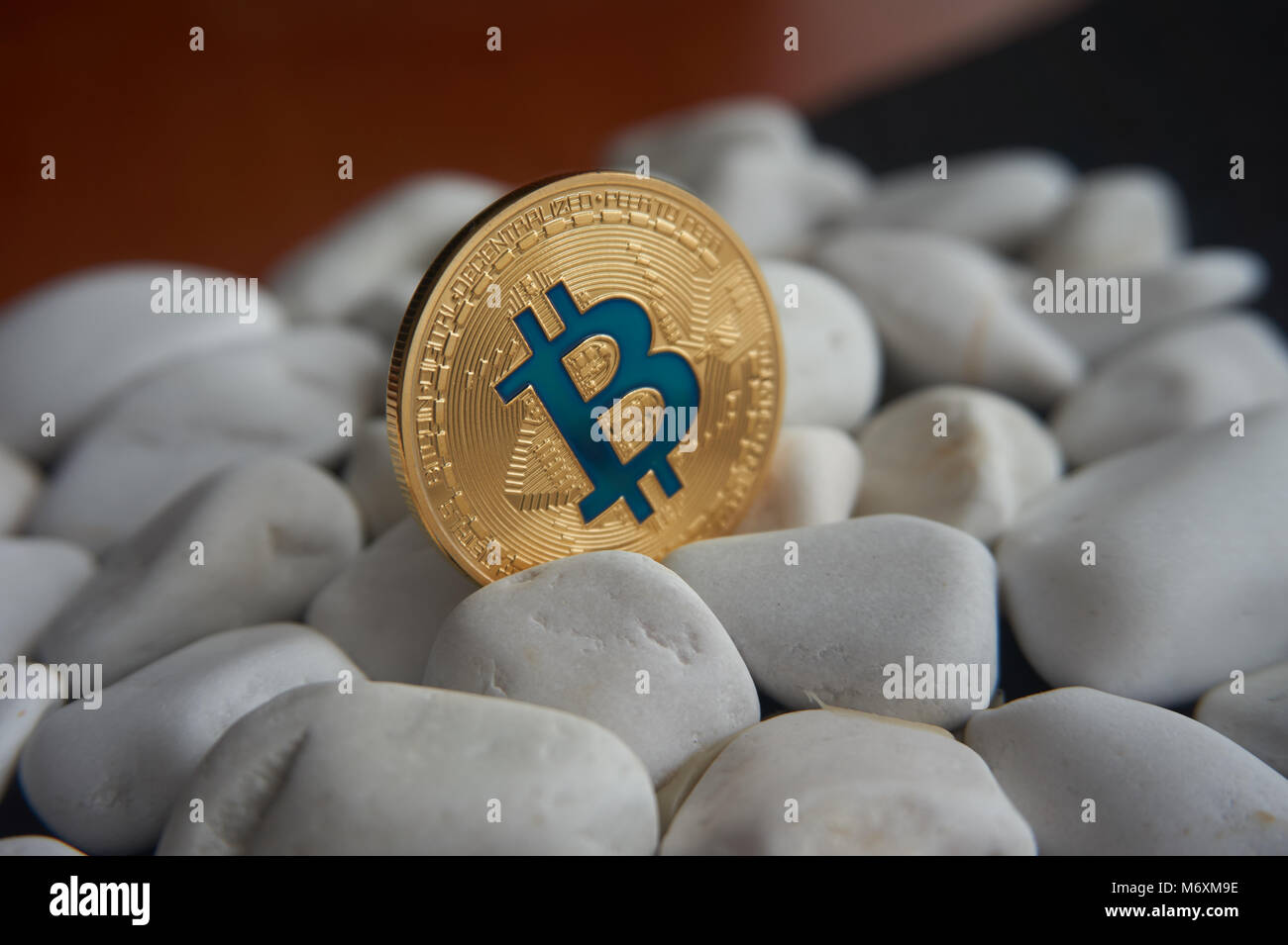 Golden bitcoin coin stuck between white stones. Cryptocurrency mining ...