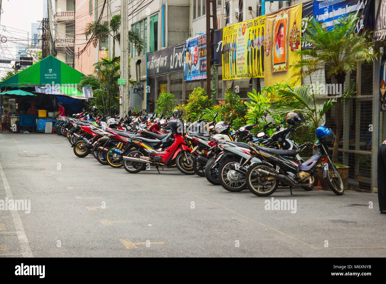 BANGKOK, THAILAND - FEB 20, 2015: Scooters parked along the street in ...