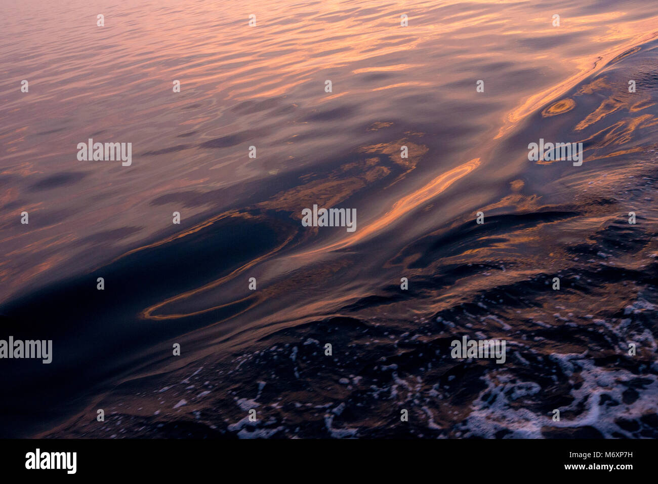 Ripples on the sea at sunset taken from a boat Stock Photo - Alamy