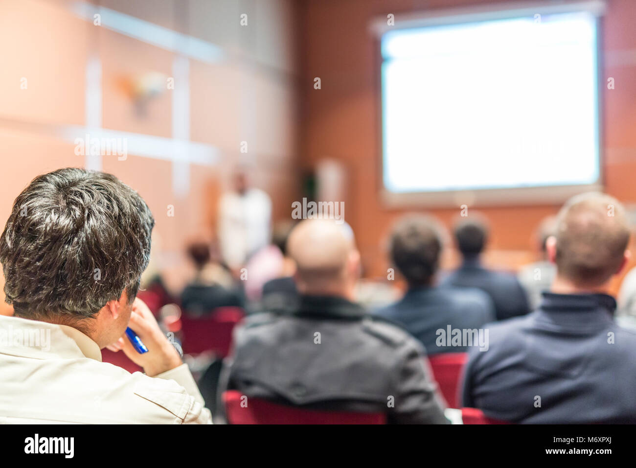 Audience in conference hall listening to presentation on business ...