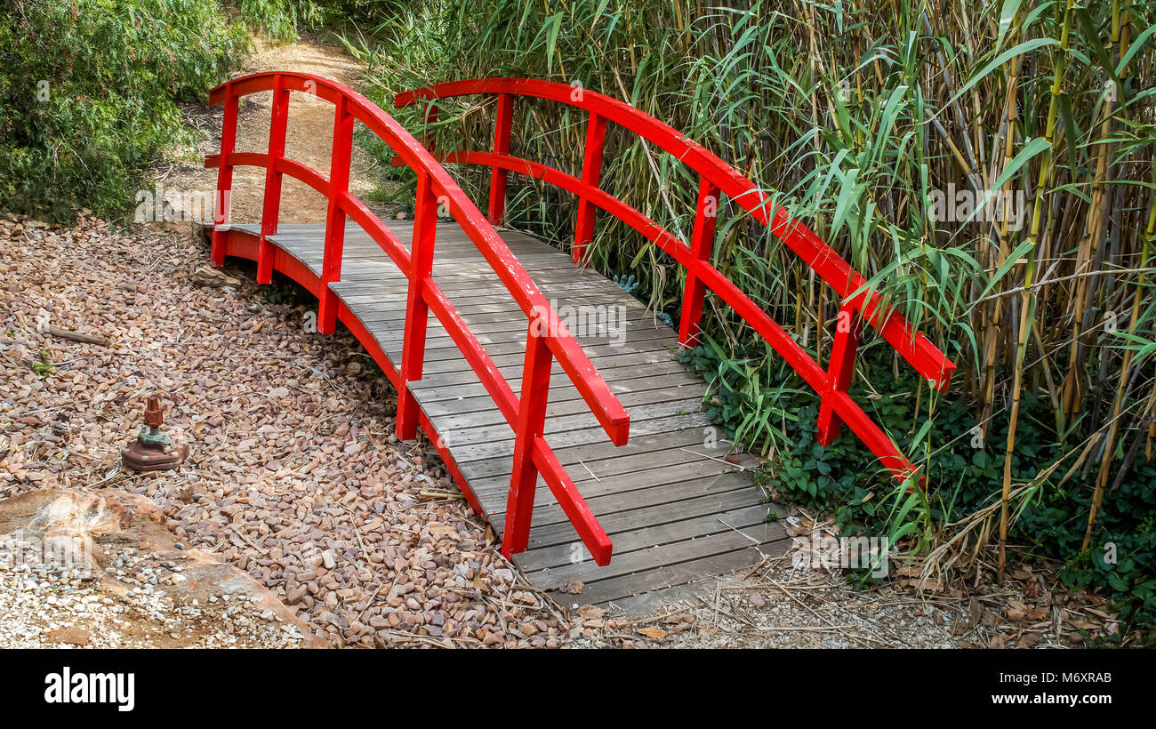 small red wooden bridge in the garden Stock Photo - Alamy